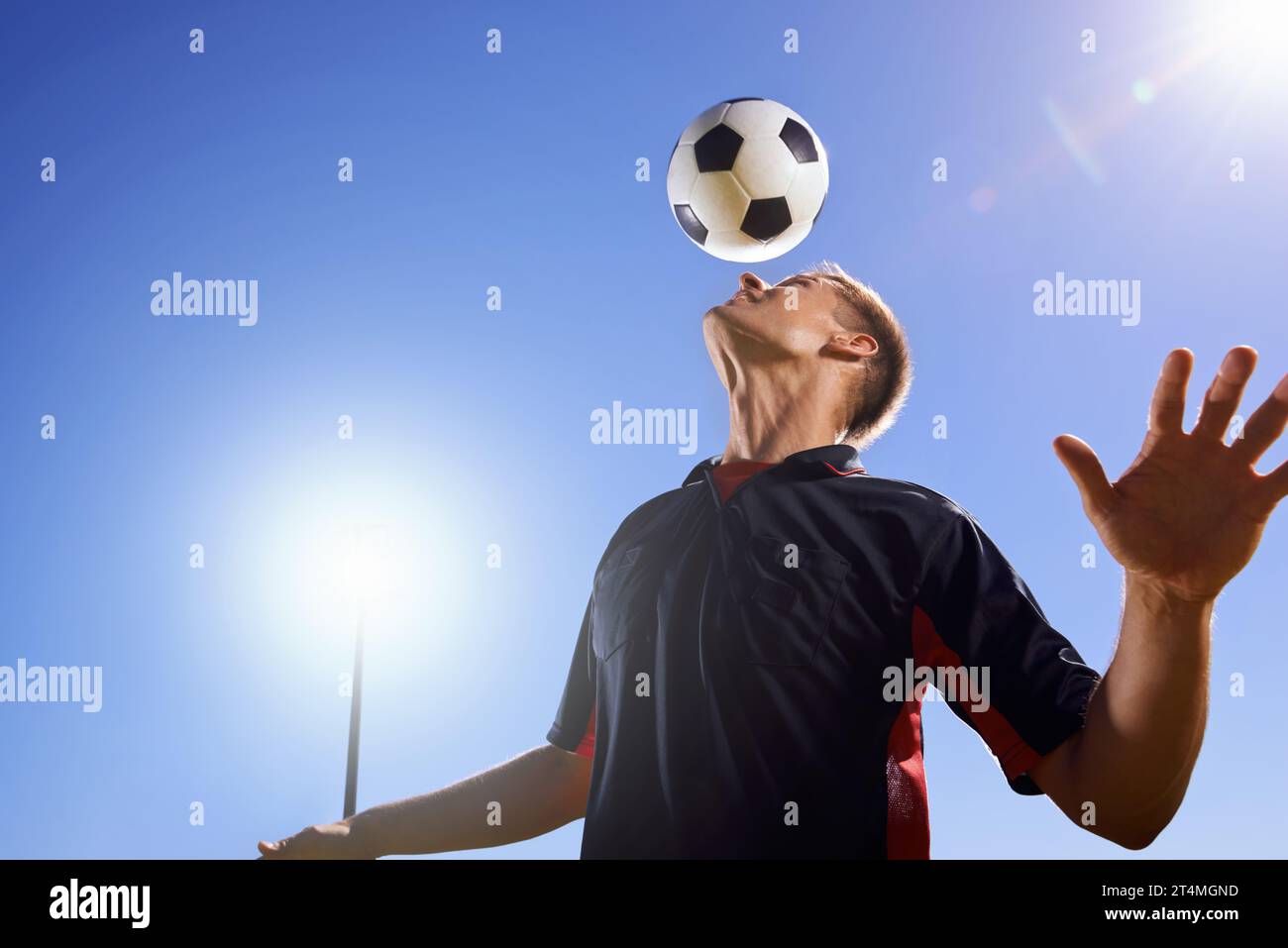 Balance and skill. a young footballer bouncing a ball on his head Stock ...