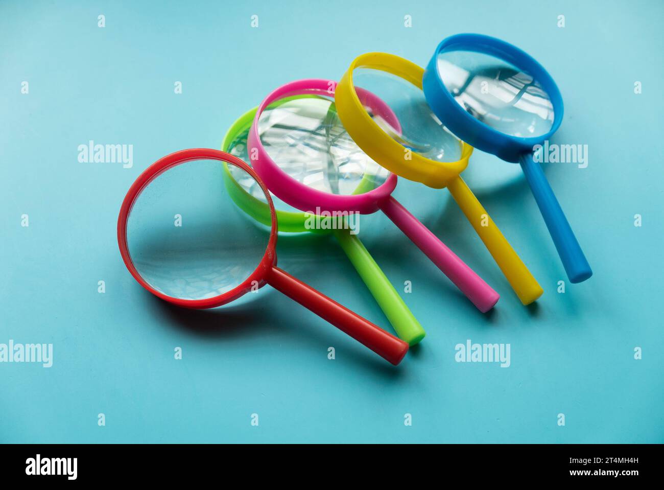 Colorful magnifying glass over a blue background Stock Photo - Alamy