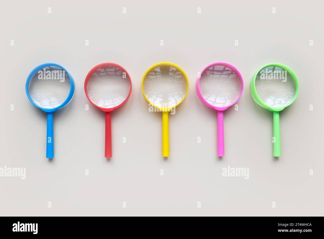 Colorful magnifying glass over a pastel background Stock Photo - Alamy