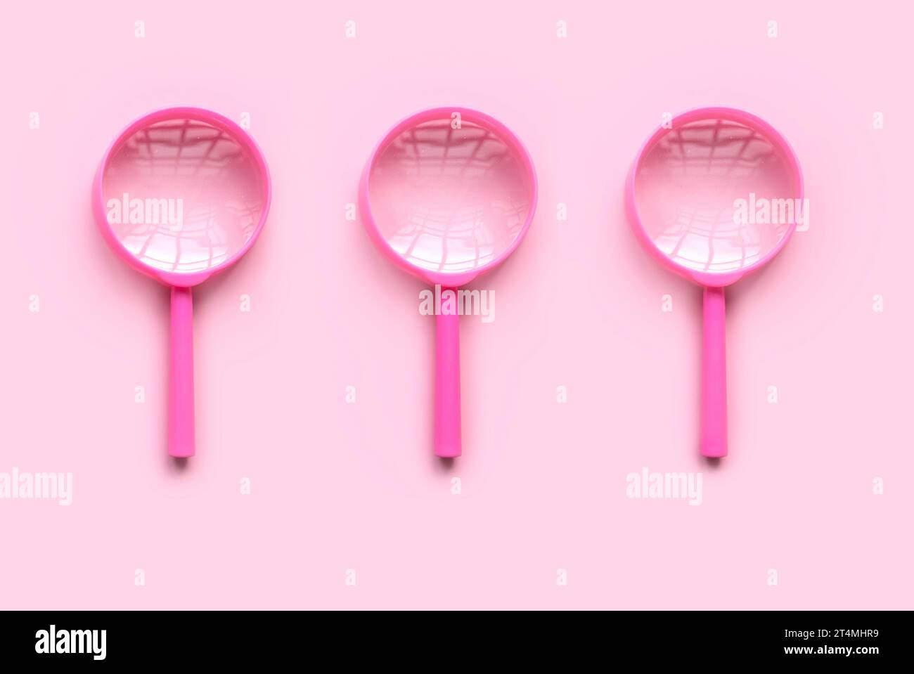 Pink magnifying glass over a pink background Stock Photo - Alamy