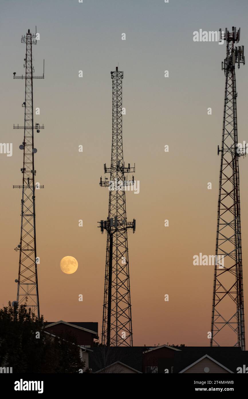 Three cell towers with the moon during sunset. Communications modern portrait concept Stock ...