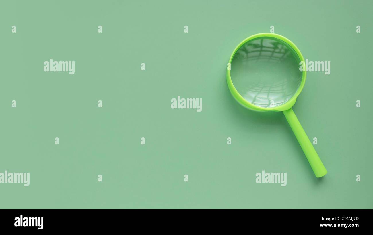 Green magnifying glass over a green background.Copy space Stock Photo ...