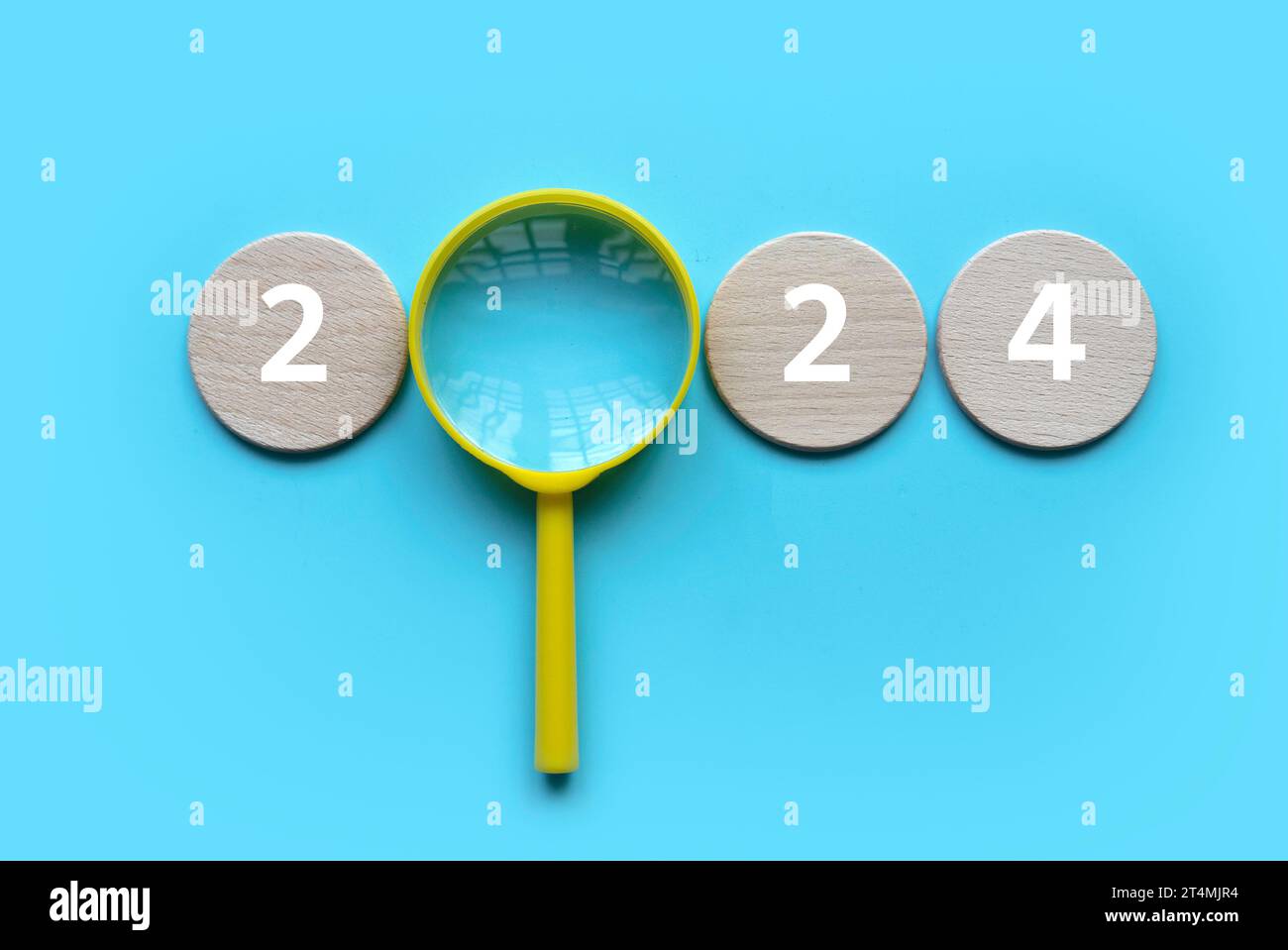 New year concept. Magnifying glass with a wooden circle with number ...