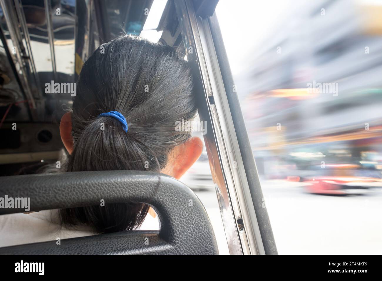 A woman watches the street from a moving city bus Stock Photo - Alamy