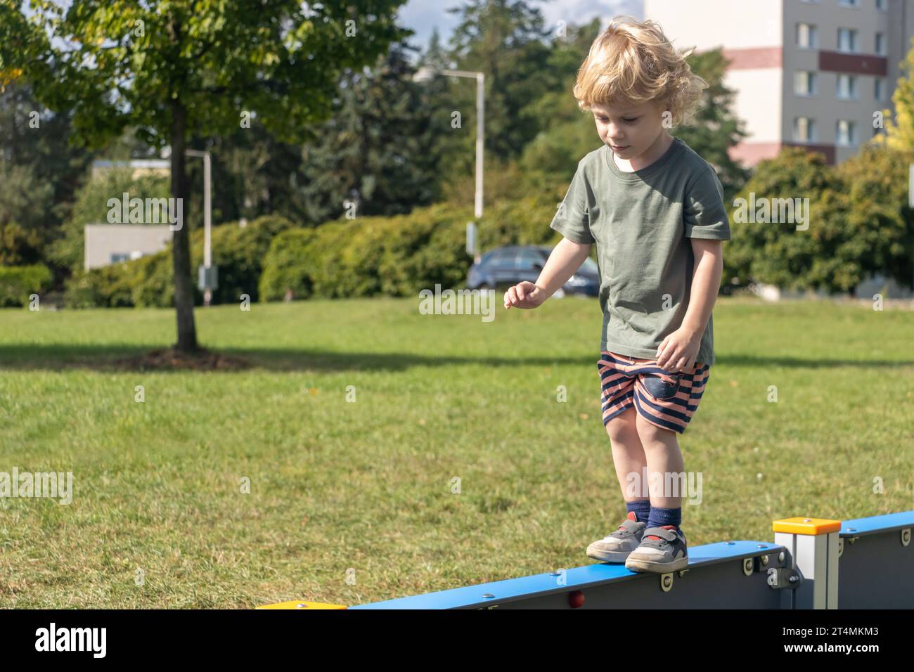 A little boy balances on a small playpen in the playground Stock Photo ...