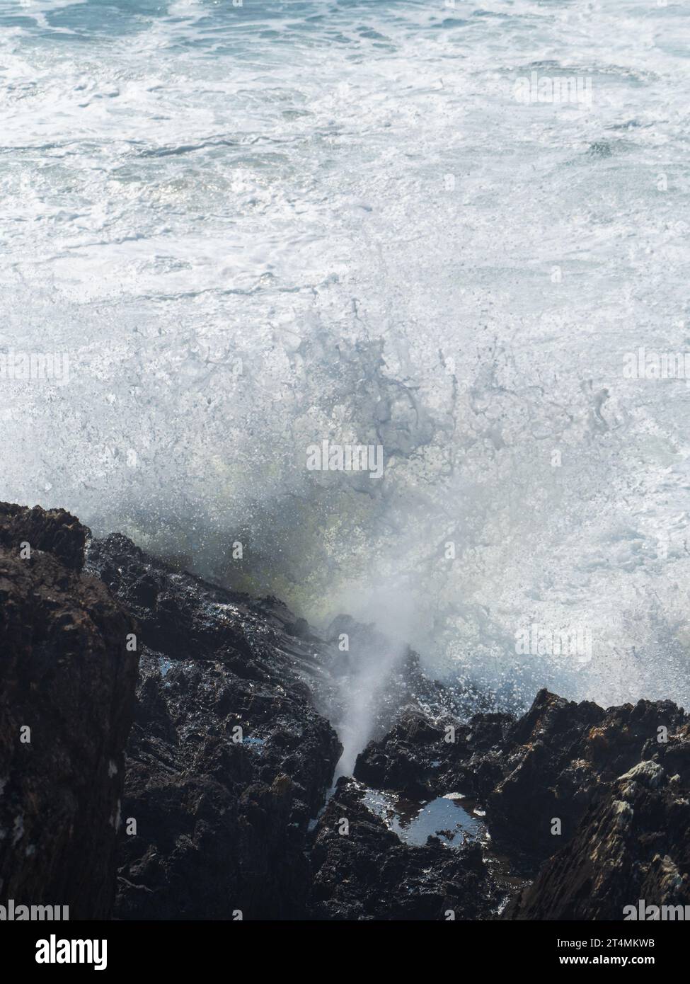 Water shooting up through a Small blowhole and into the air as waves ...