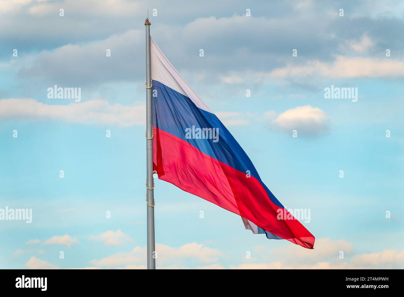 Russian tricolor flag waving in the wind against a blue sky. Russian ...