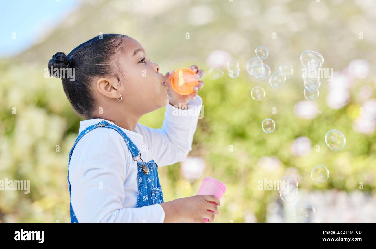 A wish sent with every bubble. a little girl blowing bubbles outside ...
