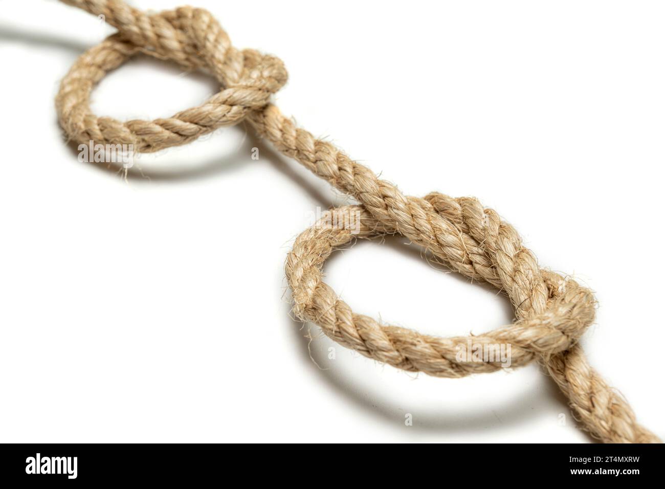 Coiled rope knot isolated over a white background Stock Photo - Alamy