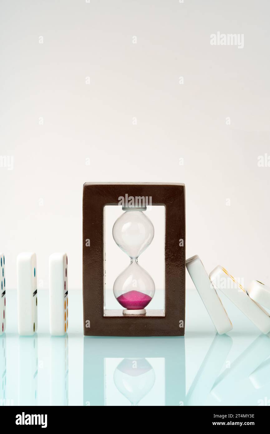 Hourglass and domino tiles on blue background. Time limit concept Stock ...