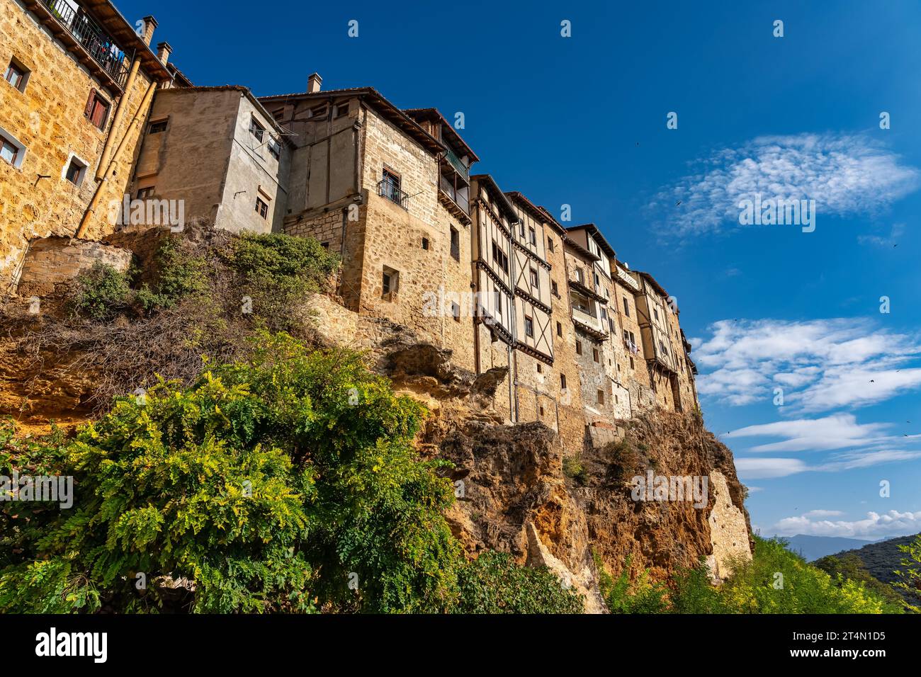 Houses perched on the cliff atop the hill of the medieval village of ...