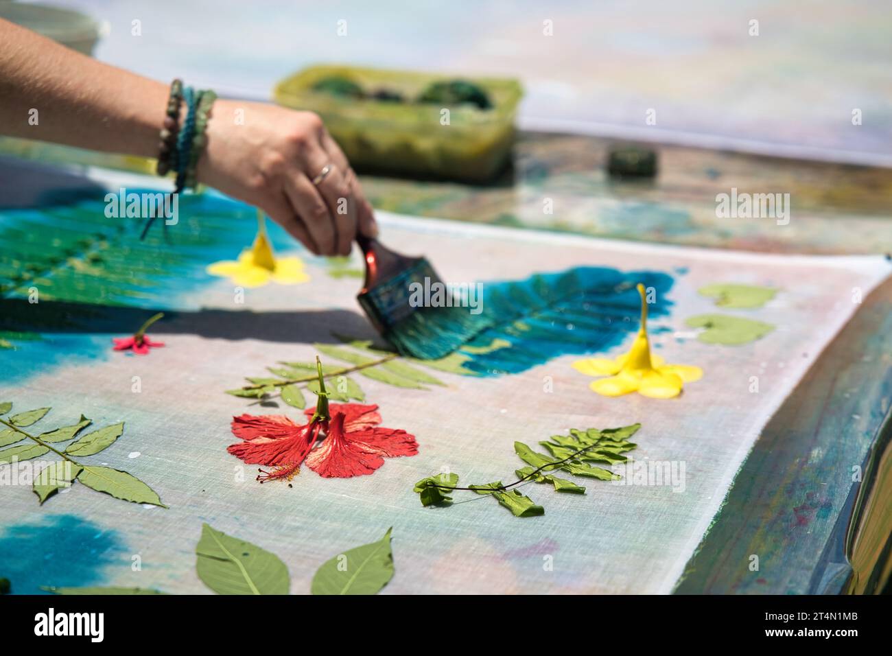 White skin woman, painting over leaves with cloth printing ink at ...