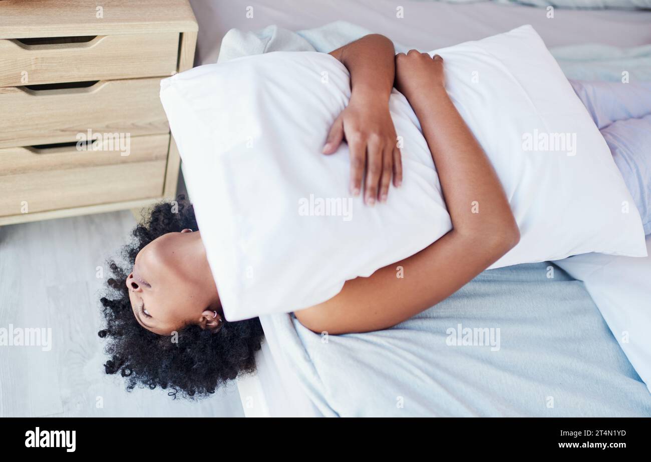 Im super bored. a woman embracing her pillow while lying on her bed ...