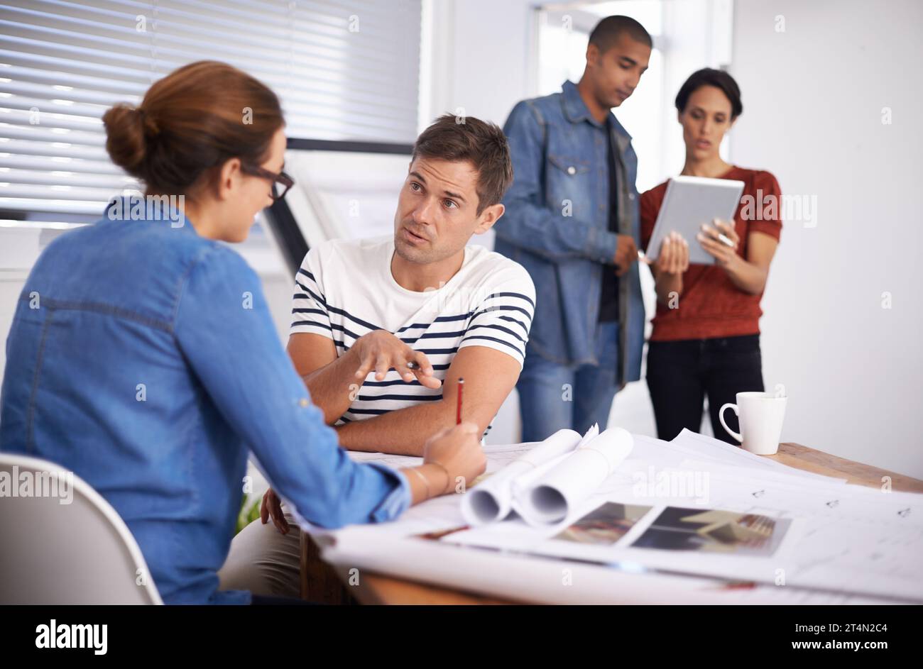 Perfecting their designs through thorough examination. a group of young ...