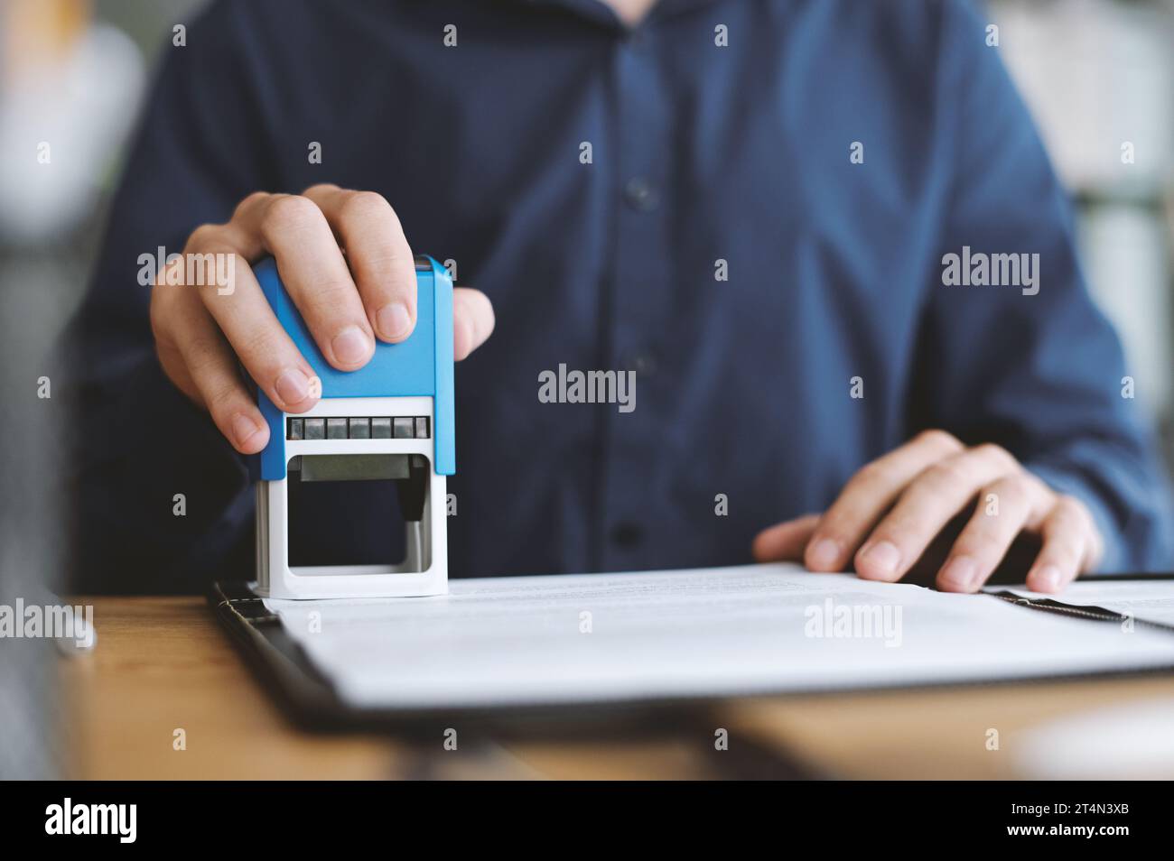 Business manager putting approval and verification stamp on agreement ...