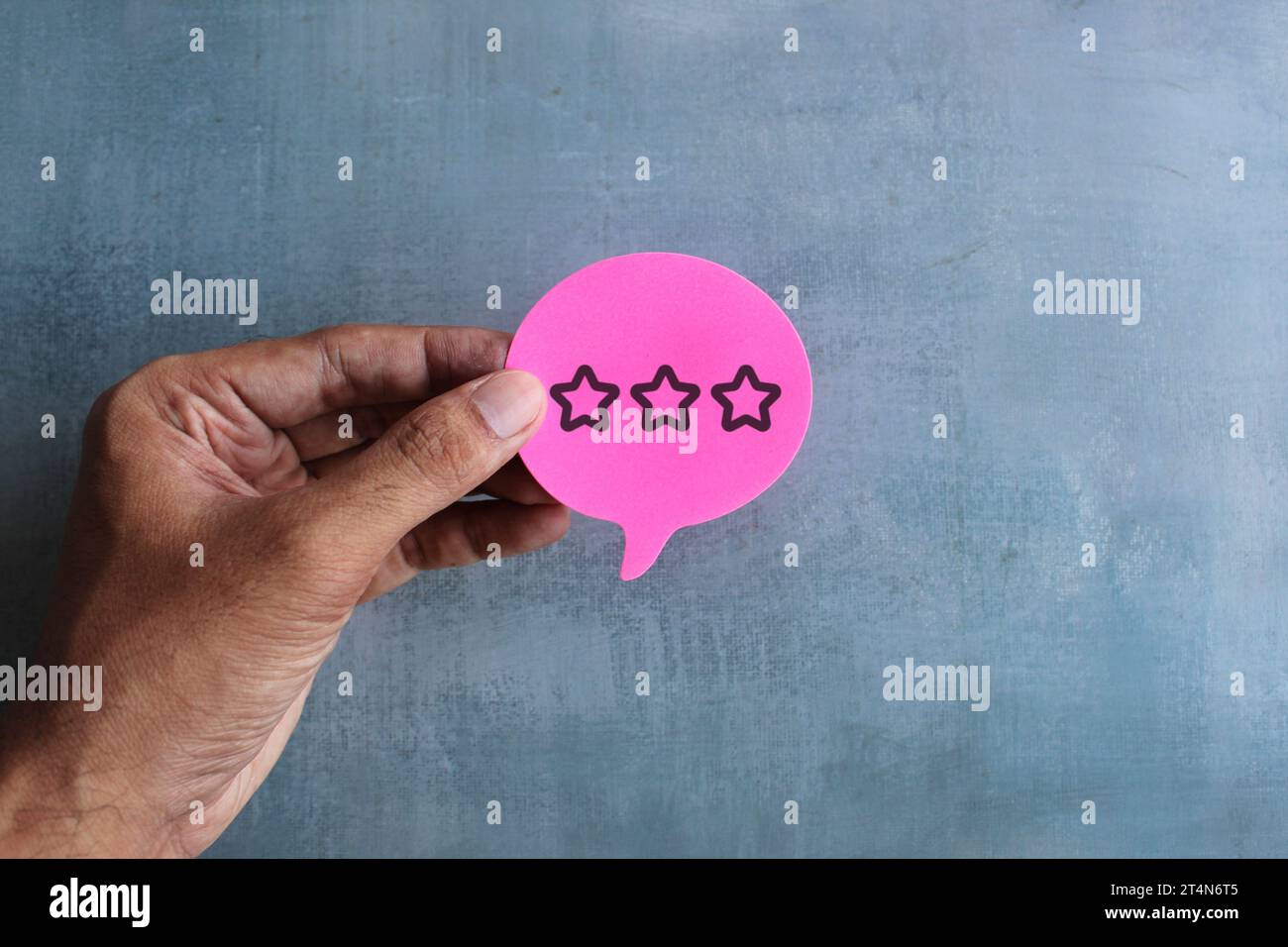 Hand holding speech bubble with star review icon. Customer feedback and ...