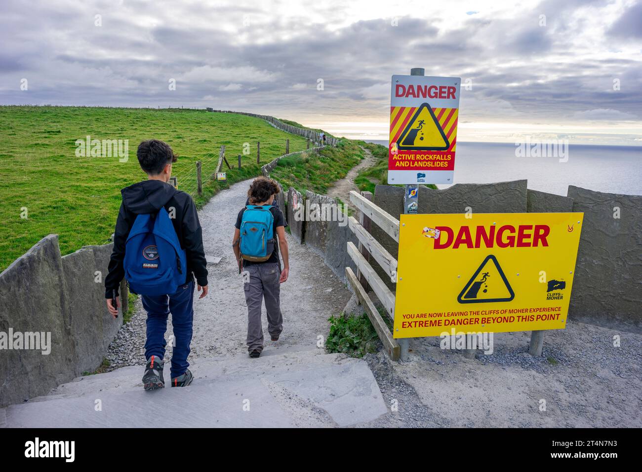 hikers and danger sign, Cliffs of Moher, The Burren, County Clare ...