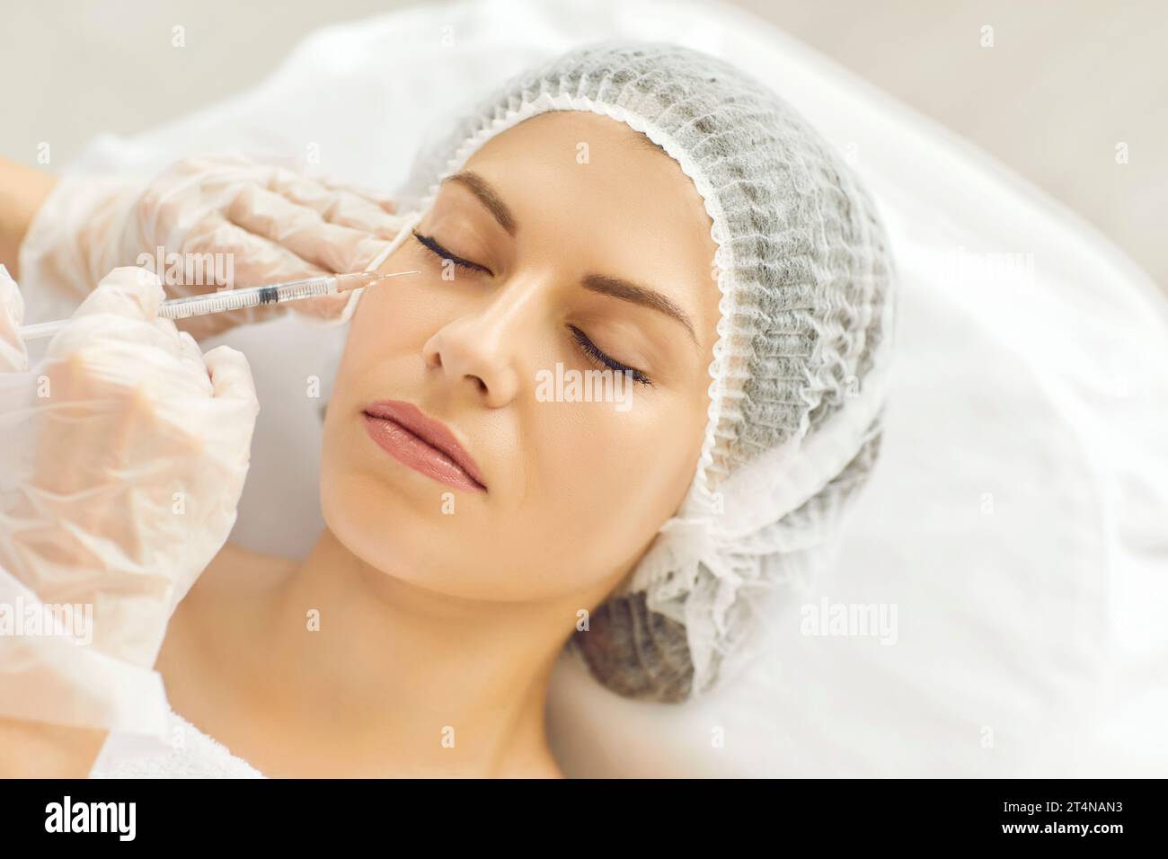 Young woman receiving professional under eye filler injection at ...