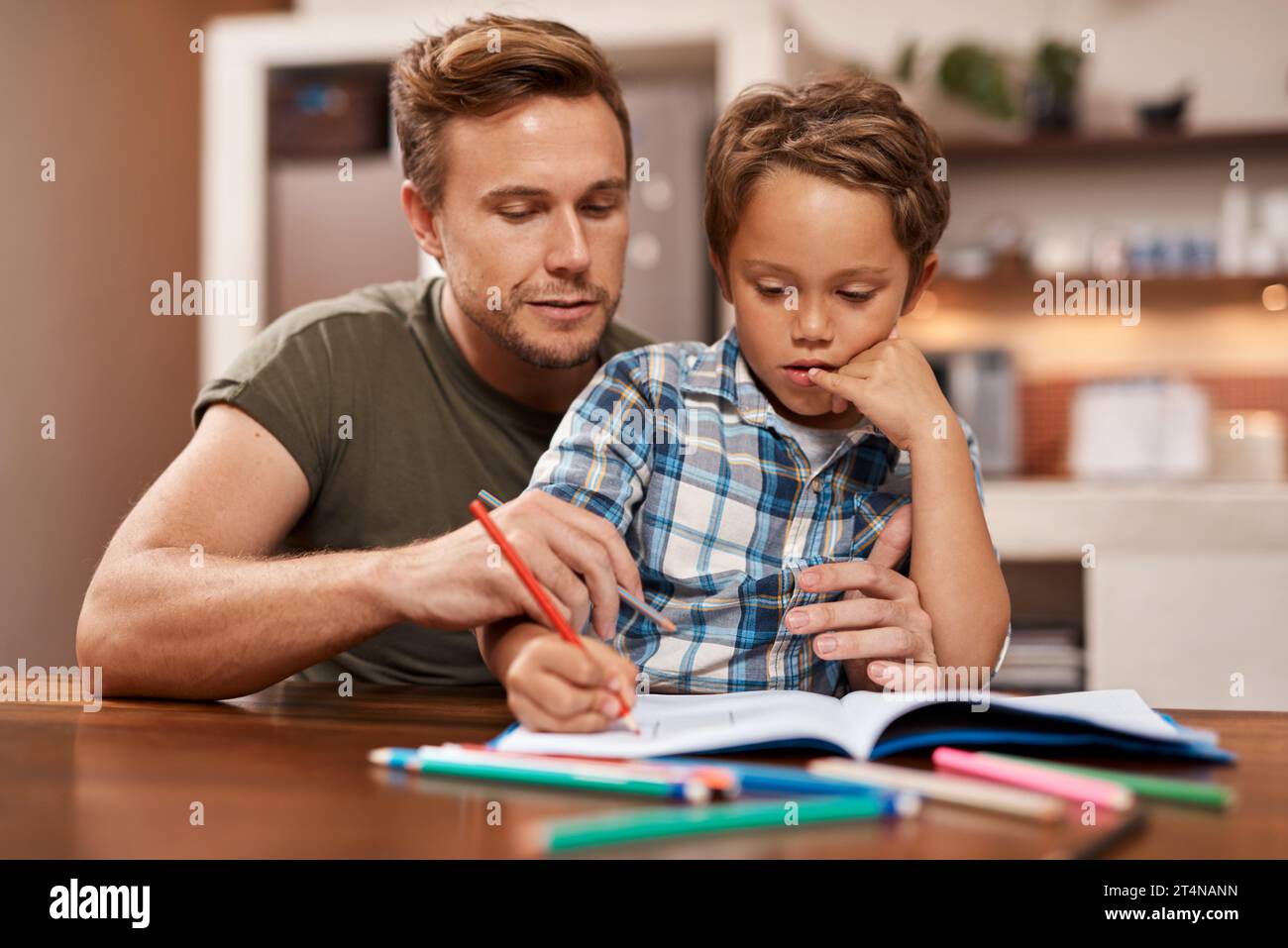 Youre doing well, buddy. a man sitting with his son while he does his ...