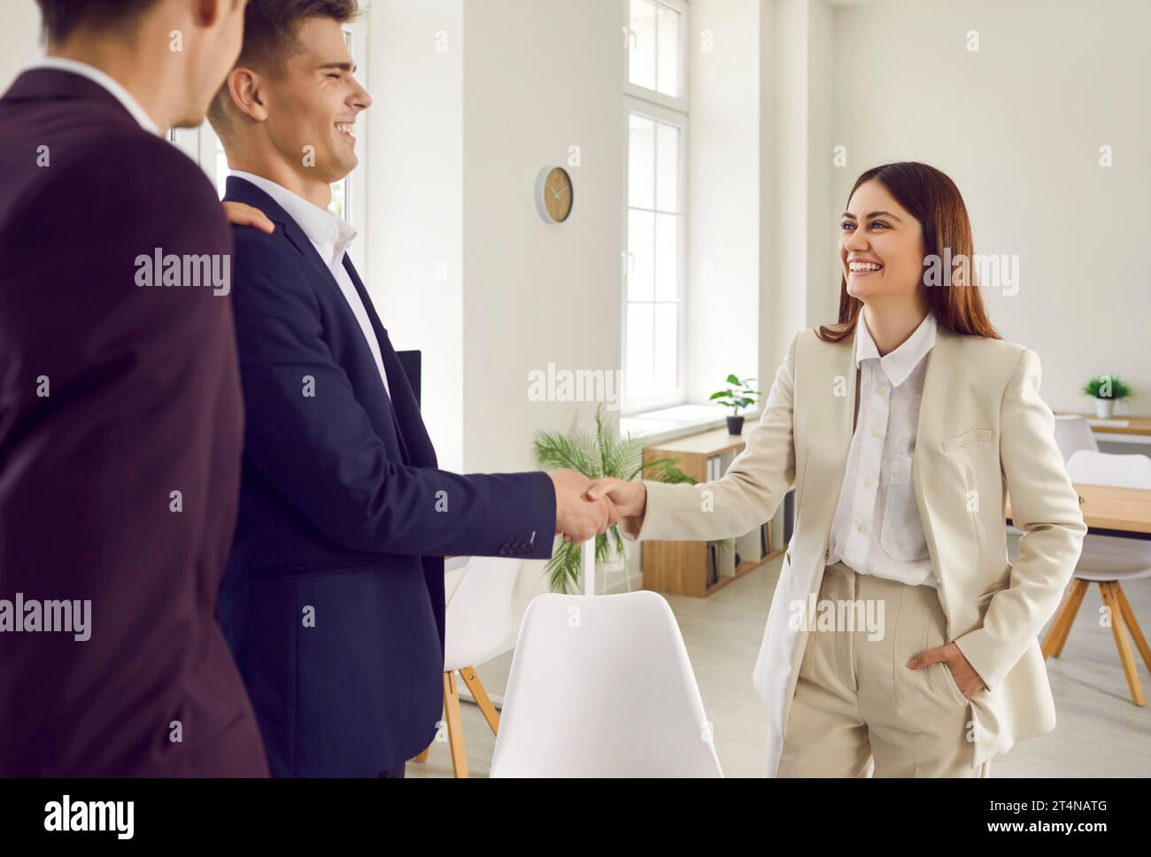 Business people standing in office and making deal shaking hands with ...