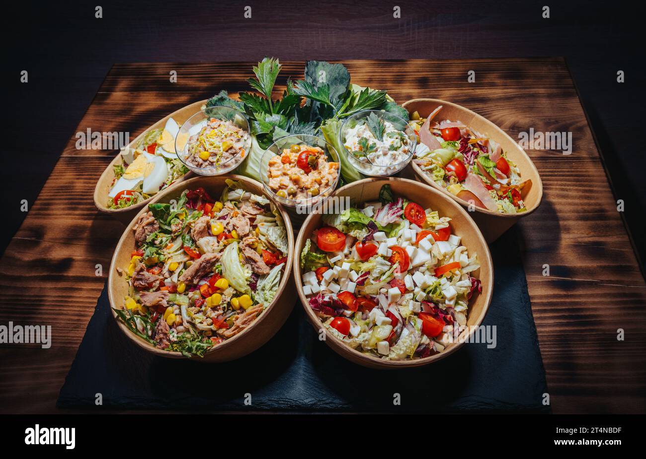 Different types of salads in a bowl on black background Stock Photo - Alamy