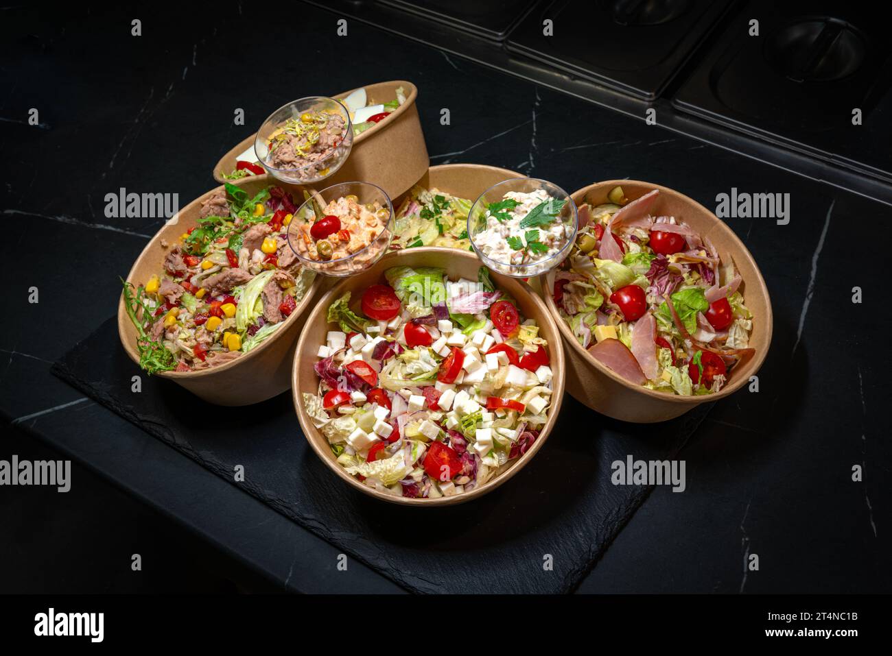 Different types of salads in a bowl on black background Stock Photo - Alamy