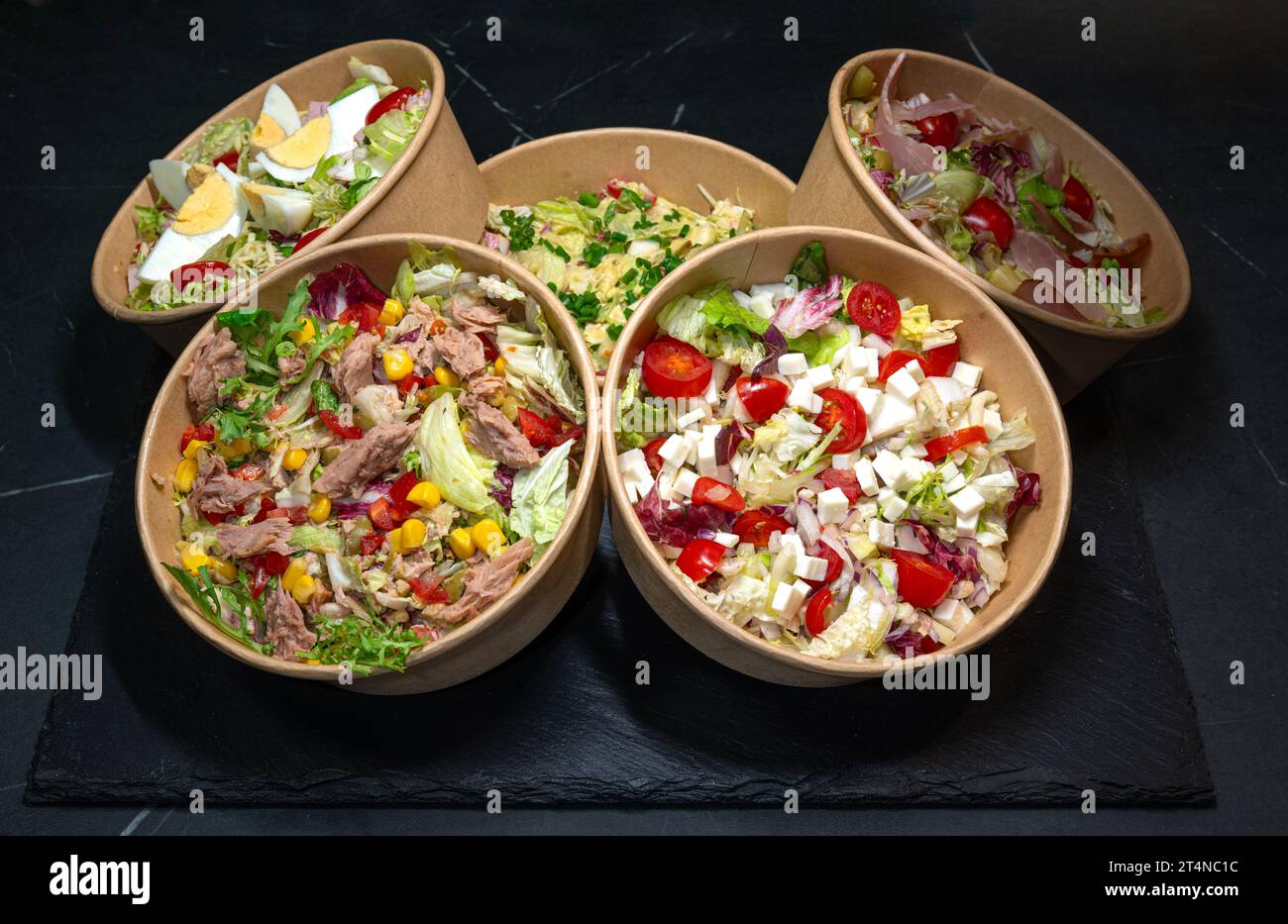 Different types of salads in a bowl on black background Stock Photo - Alamy