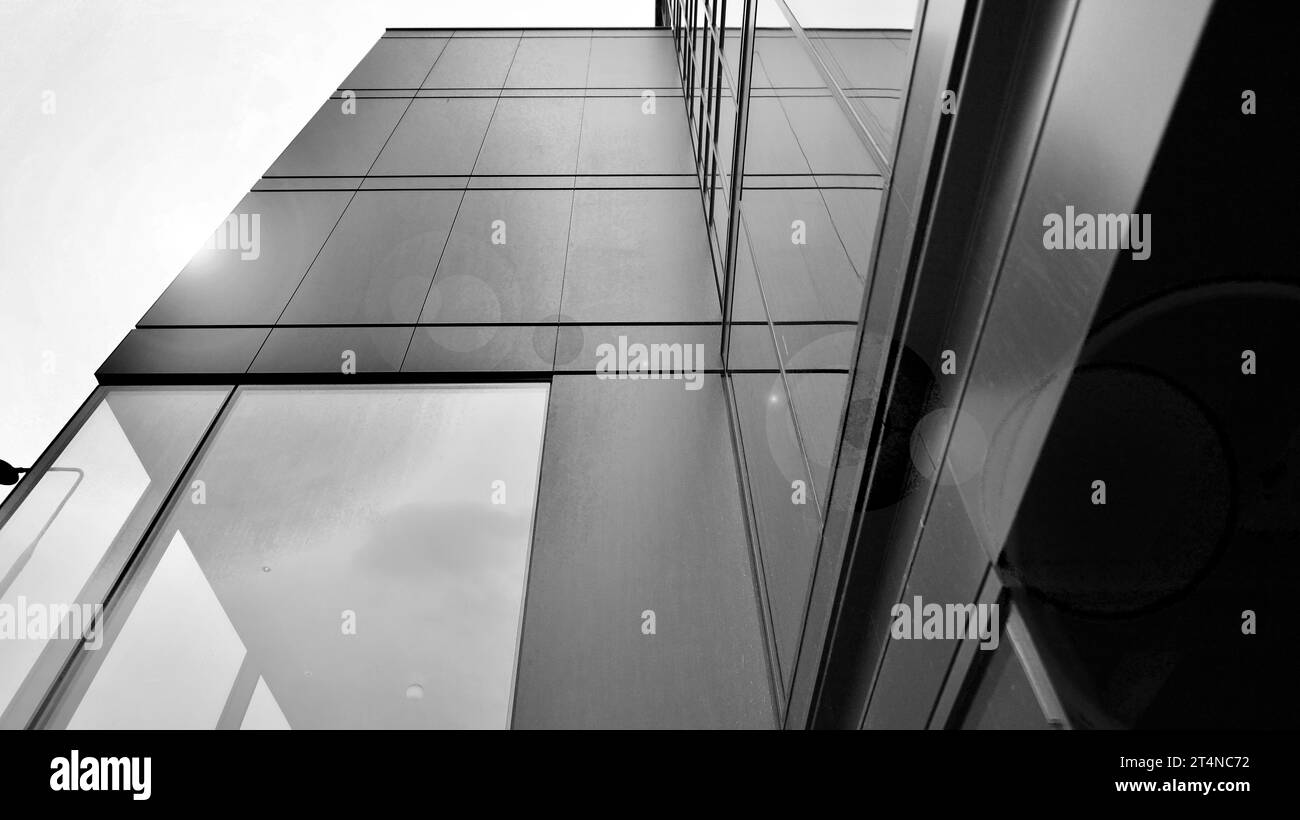 A view at a straight facade of a modern building with a dark grey ...