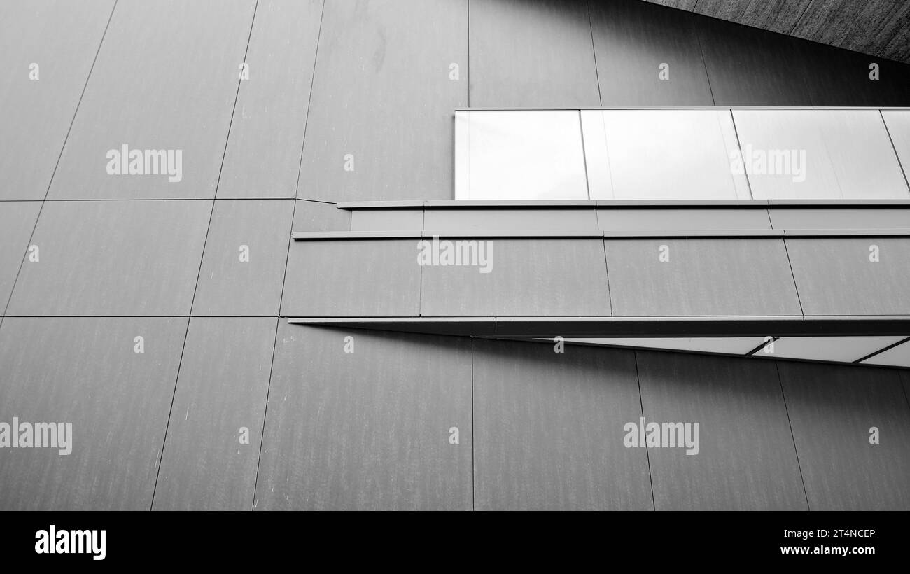A view at a straight facade of a modern building with a dark grey ...