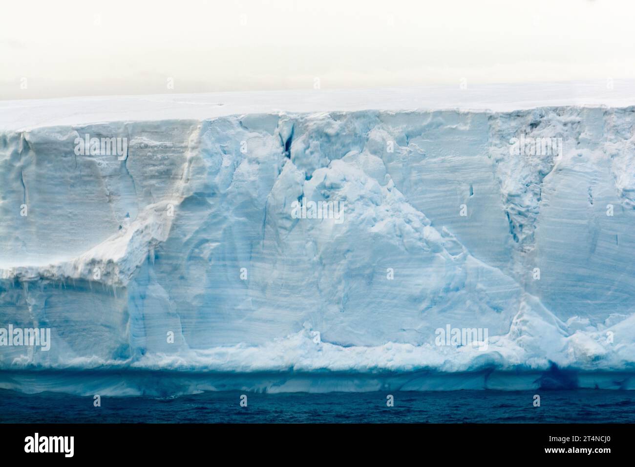close-up of ice cliff edge of large tabular iceberg in waters of ...