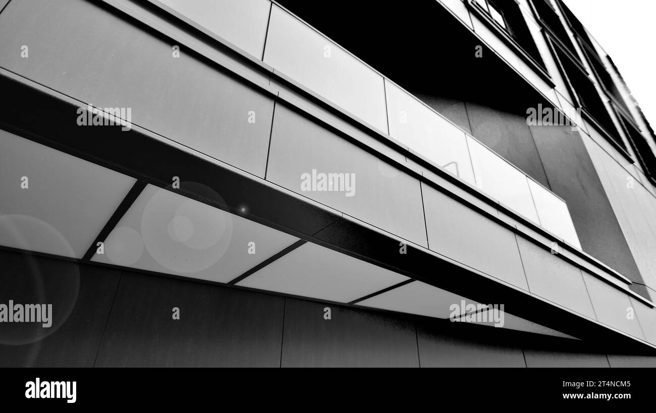 A view at a straight facade of a modern building with a dark grey ...