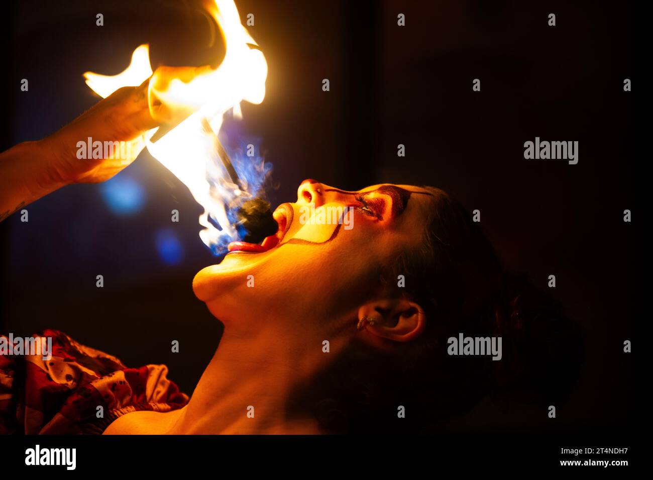 woman performs fire breathing and eating during the halloween weekend ...