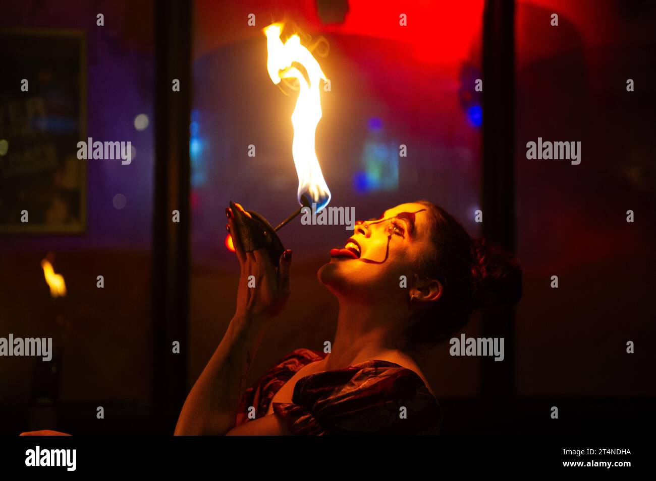 woman performs fire breathing and eating during the halloween weekend ...