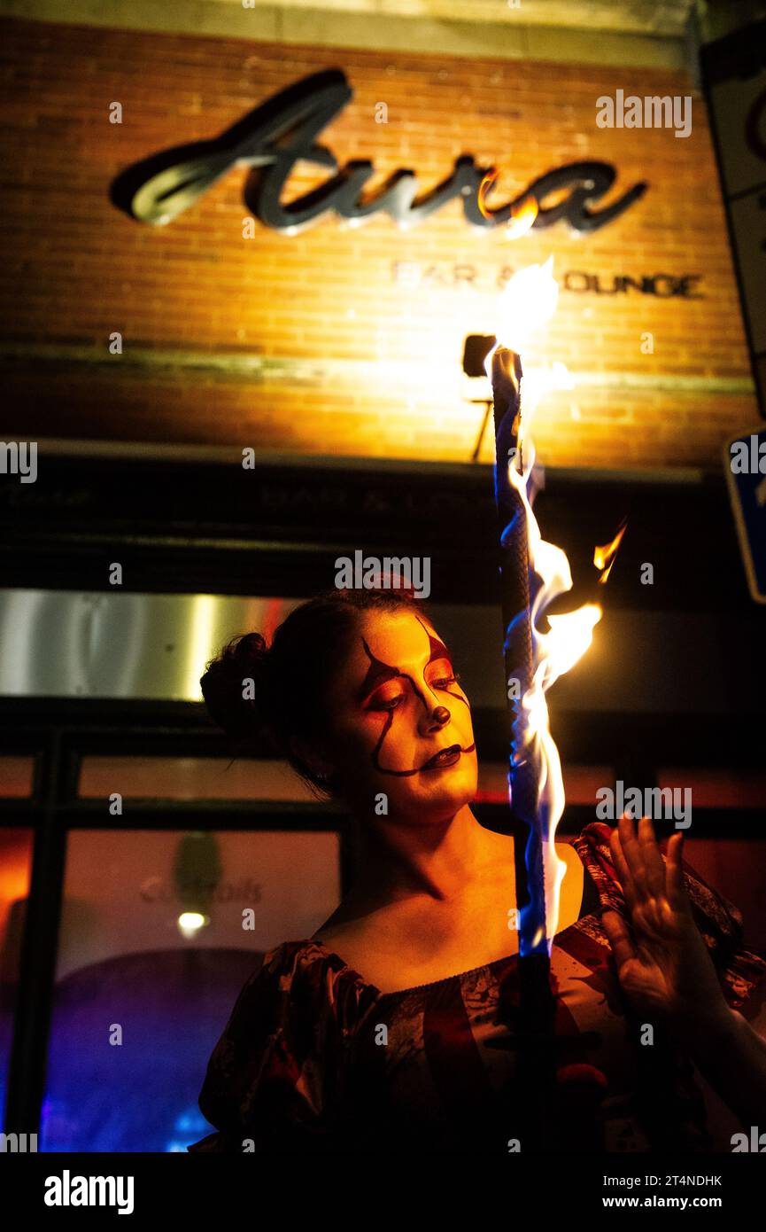 woman performs fire breathing and eating during the halloween weekend ...