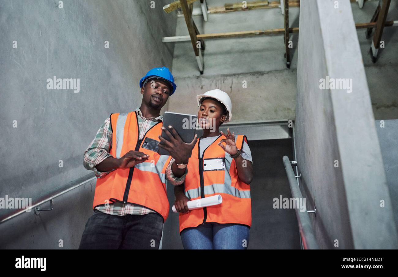 Quality work from concrete to completion. a young man and woman using a ...