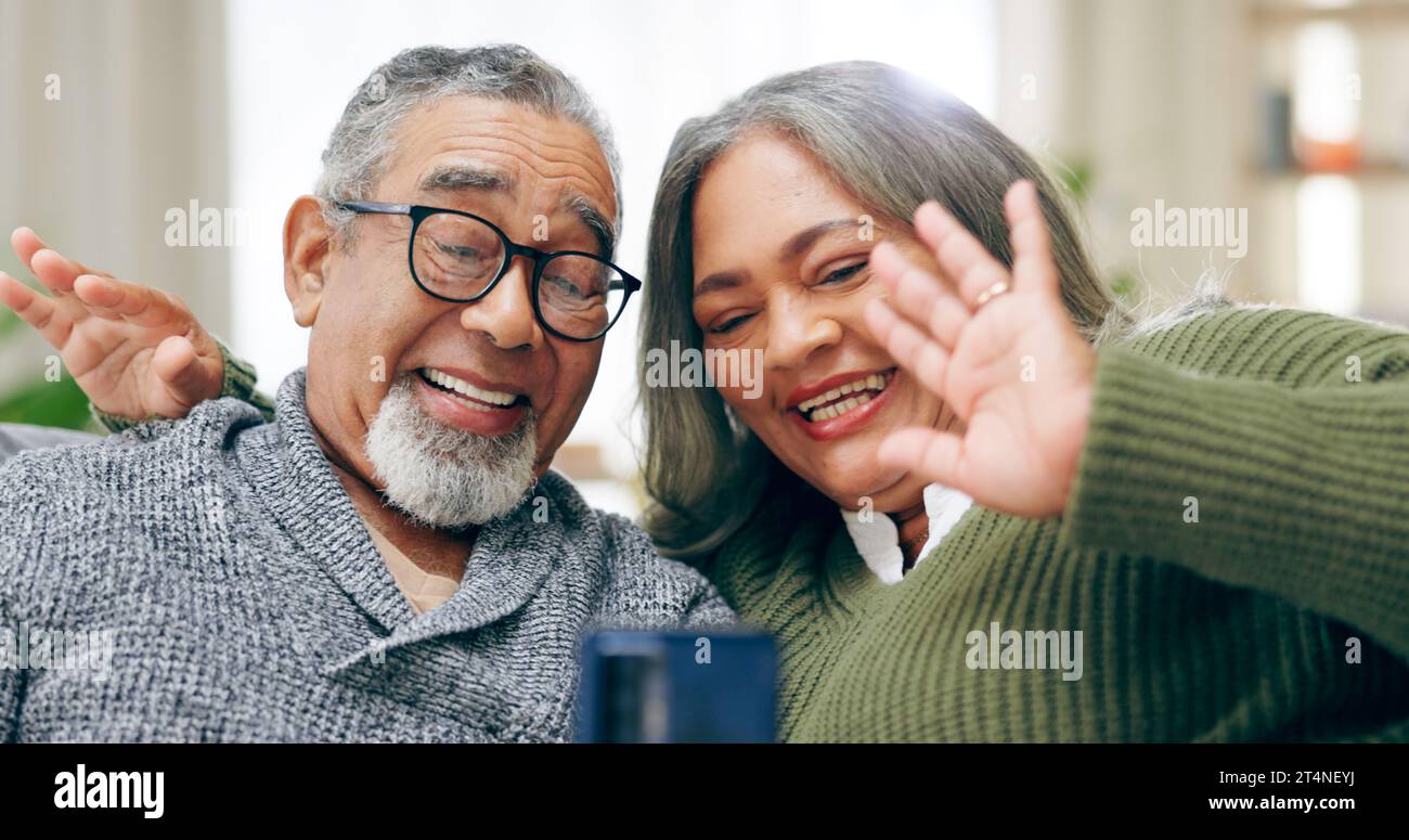 Senior couple, video call and phone on sofa with wave hello, smile and ...