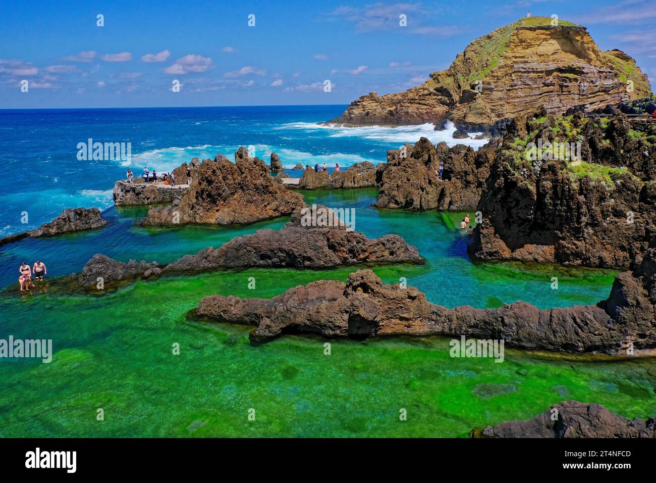 Natural swimming pool with sea water, lava rocks, swimmers, Porto Moniz, north coast, Madeira ...