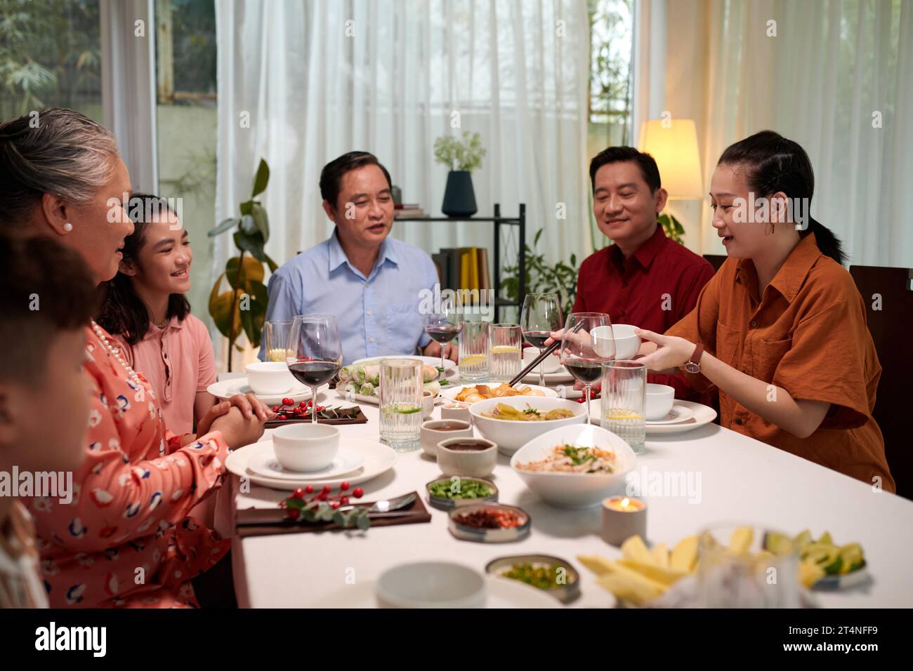 Big Vietnamese family eating traditional dishes at family celebration ...