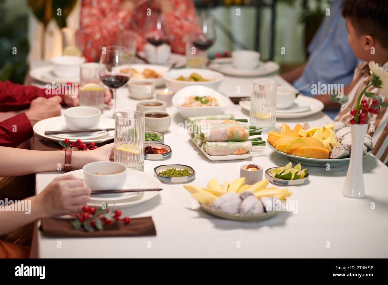 Vietnamese family eating at table with traditional appetizers and ...