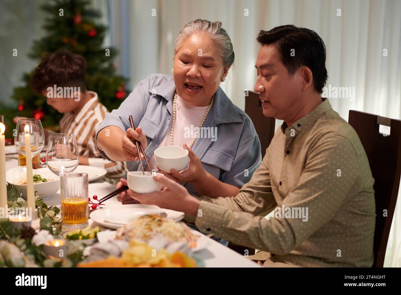 Vietnamese family members enjoying traditional dishes at Christmas ...