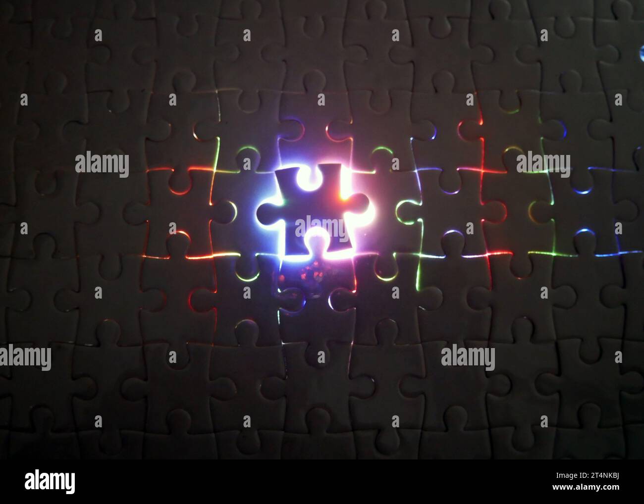 Missing piece of jigsaw puzzle with glowing light in the dark, business ...