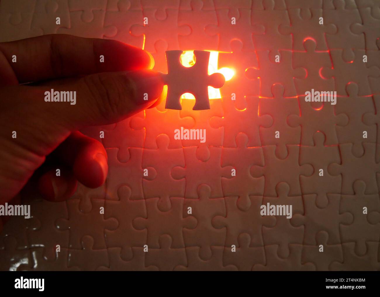 Missing piece of jigsaw puzzle with glowing light in the dark, business ...