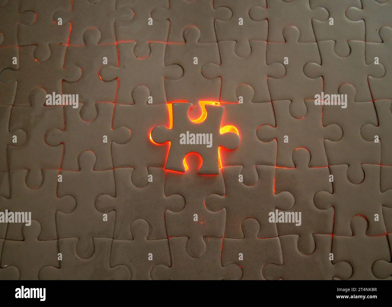 Missing piece of jigsaw puzzle with glowing light in the dark, business ...