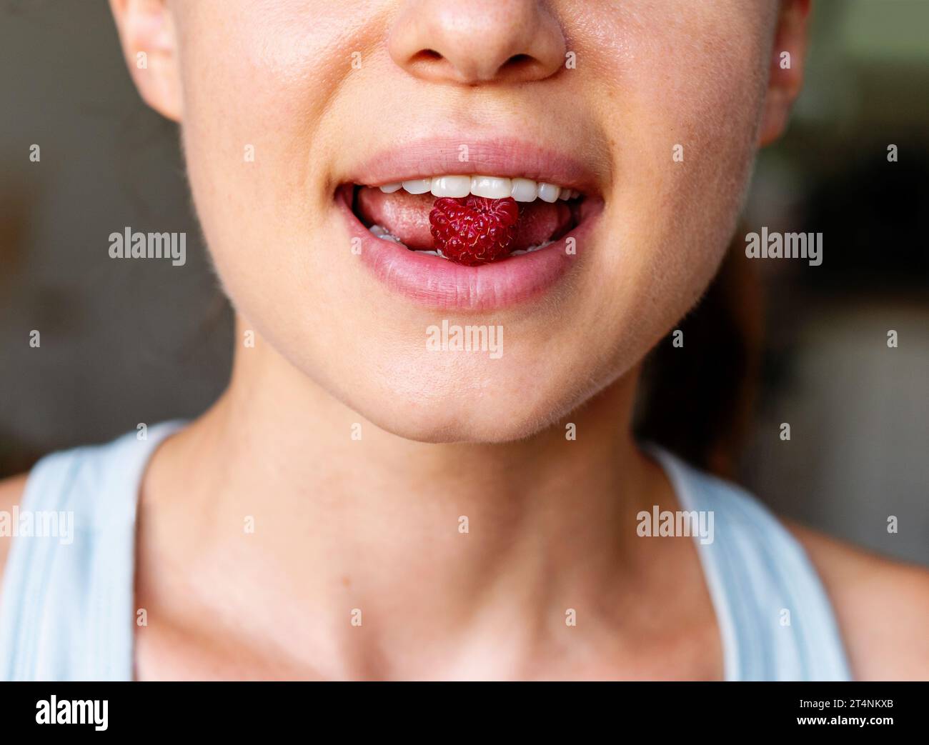 Red raspberries in female mouth close-up. Woman eating raspberries ...