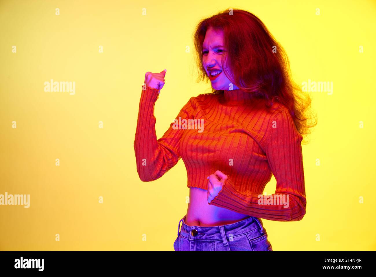 Young girl expressing excitement and cheering emotions against yellow ...