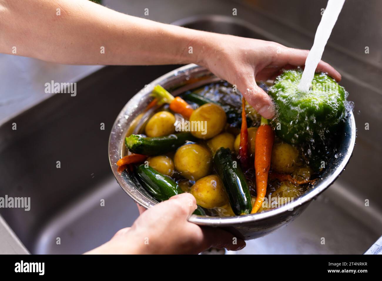 Male chef washing vegetables in commercial kitchen sink Stock Photo - Alamy