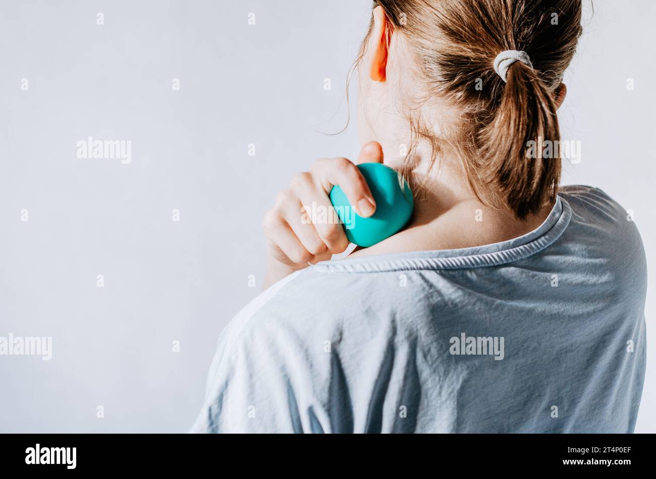 Woman doing upper back self massage with MFR therapy ball Stock Photo ...