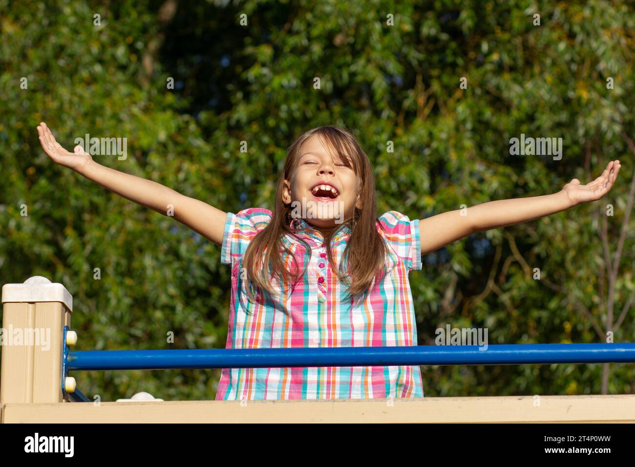 Happy child smiling raising hands up with closed eyes showing happiness ...