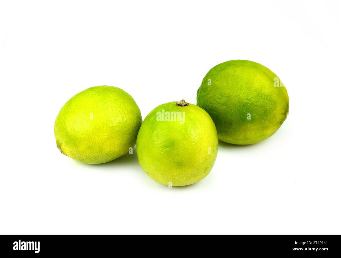 three whole limes on a white isolated background Stock Photo - Alamy
