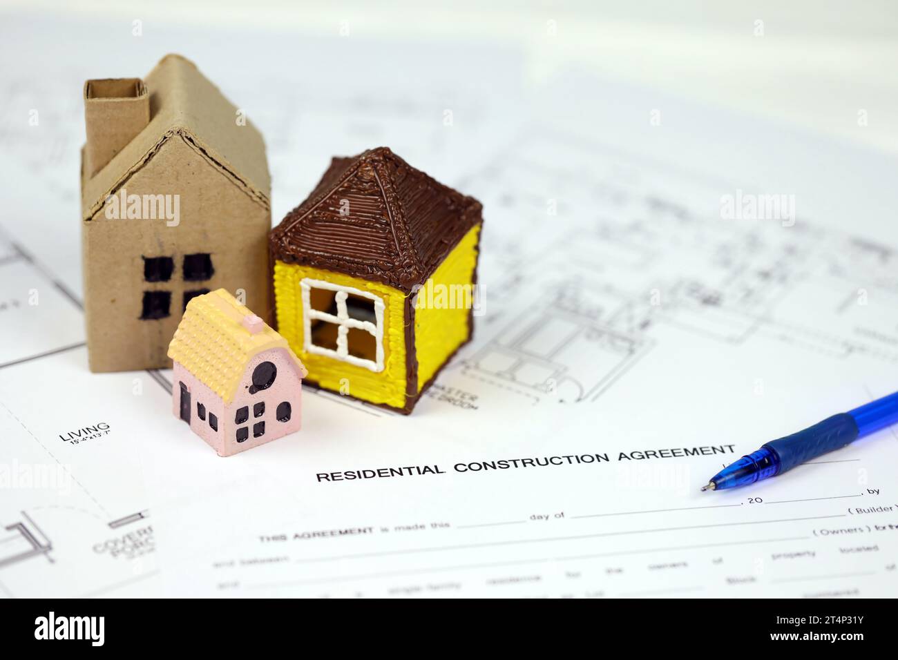 Residential construction agreement ready to sign with small toy houses ...